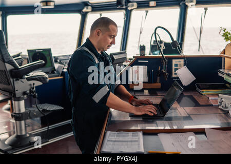 Marine navigational officer is using laptop or notebook at sea Stock ...