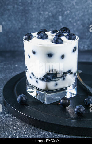 Yogurt with blue blackthorn berries in a glass. Berry dessert Stock ...