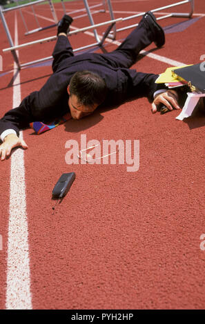 Young businessman fallen over hurdle on running track, USA Stock Photo ...