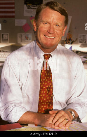 Smiling and confident middle aged executive businessman with laptop ...