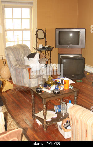 Interior of messy living room with armchair and overturned coffee table ...