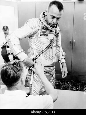 Astronaut Alan Shepard, being helped out to his space suit aboard ...