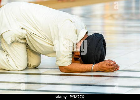 A Sikh devotee is praying at the holy pool of the Harmandir Sahib, the ...