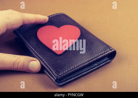 Heart shape and wallet in hand as finance concept Stock Photo - Alamy