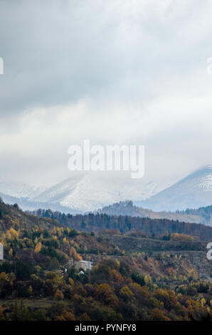 Contrast between autumn hills and snow covered high mountains Stock ...