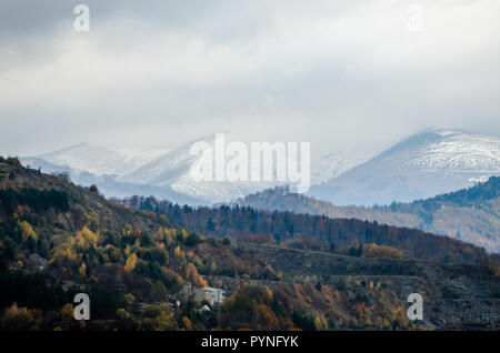 Contrast between autumn hills and snow covered high mountains Stock ...