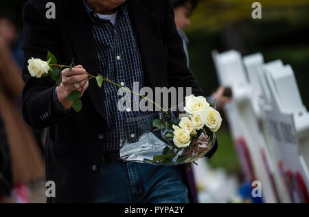 A mourner placing a flower at a memorial in a funeral home for the ...