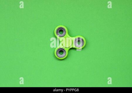 Green fidget spinner lies on texture background of fashion pastel green ...