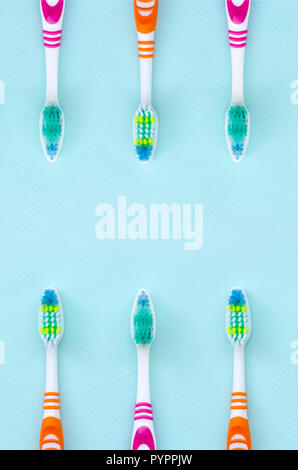 A lot of toothbrushes lie on a pastel pink background. Top view, flat ...