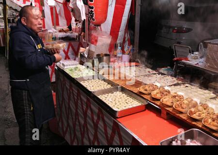 CHICHIBU, JAPAN - DECEMBER 3, 2016: Vendor prepares street food at ...