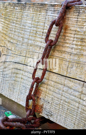 Rusty chain links on wood close up vertical Stock Photo - Alamy