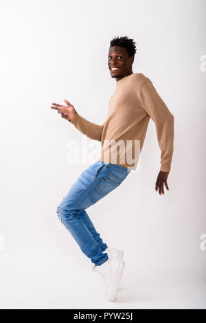 Full body shot of young African man in traditional clothing with fist ...