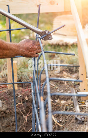 Construction worker bending rebar using manual bending machine at a ...