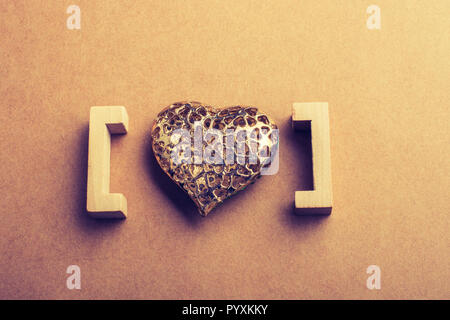 Gold color heart shaped l decorative object in view Stock Photo - Alamy