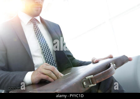businessman's hand with suitecase in a modern office Stock Photo - Alamy