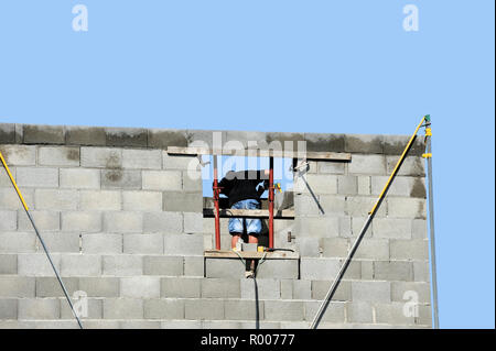 Bricklayer putting down another row of bricks in site during the ...