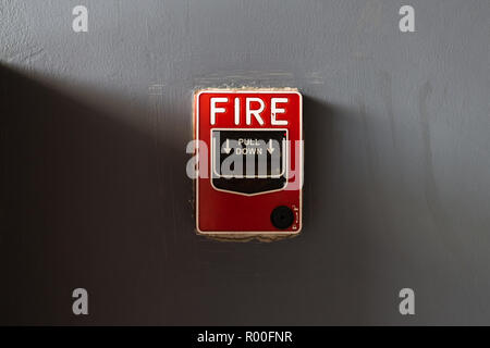 Manual fire alarm activation pull station on wall - signage reading ...