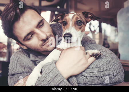 Man cuddling with his dog in winter Stock Photo - Alamy