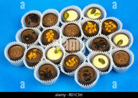 Chocolate candies with various fillings in a paper wrapper on a bright ...