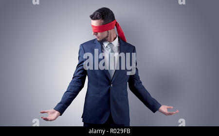 Covered eye, indecisive businessman standing blind in front of a wall ...