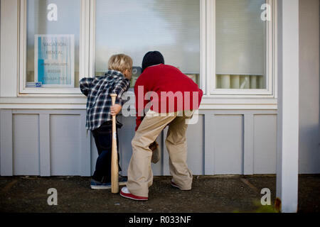 Two boys peering into window of an empty house Stock Photo - Alamy