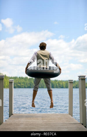 Happy young man jumping around at a hedge Stock Photo - Alamy