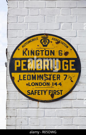 Old yellow and black AA distance sign fixed to house wall at Newent ...