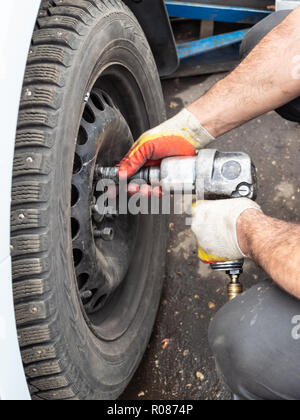 mechanic with wheel tire at car workshop Stock Photo - Alamy