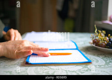 Studing human writing writing in a notebook Stock Photo - Alamy