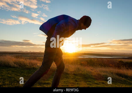 Man walking into a strong wind. UK Stock Photo - Alamy