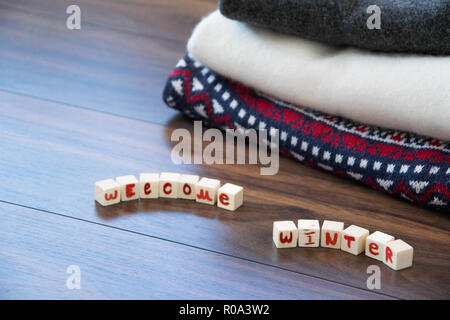Crop view of woolen sweaters with "Welcome Winter" text, fashion ...