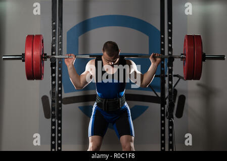 Powerlifter Working Out Legs With Barbell In A Gym - Squat Exercise ...