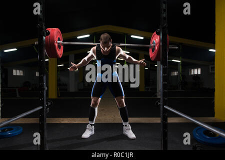 Healthy Powerlifter Man Working Out Legs With Barbell In A Gym - Squat ...