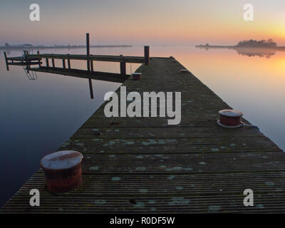 Bent jetty during sunset over lake Stock Photo - Alamy