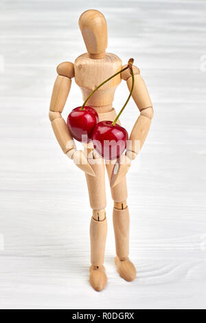 Wooden dummy with red ripe cherries Stock Photo - Alamy