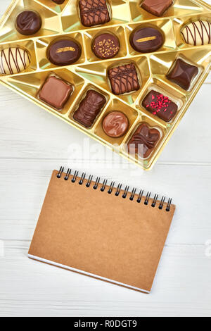 Group of chocolate candies and paper notebook Stock Photo - Alamy