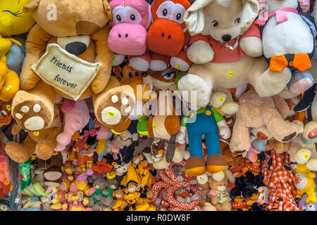 A collection of arcade game prizes on display in an amusement park ...
