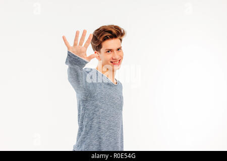 Smiling young guy welcomes saying goodbye to hand on white background ...
