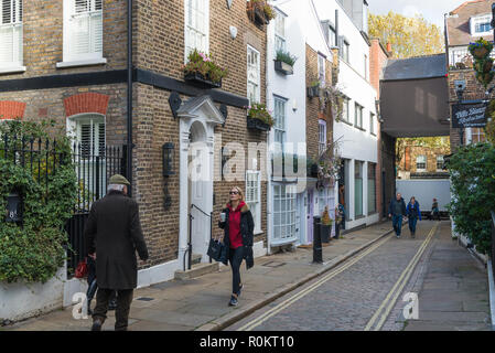 People walking through Perrin's Court, a pretty narrow street of shops ...