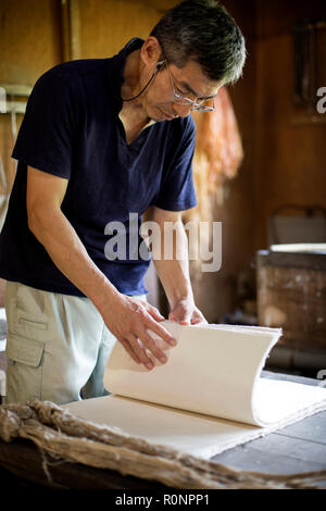 Asian man owner a small furniture business is preparing wood for ...
