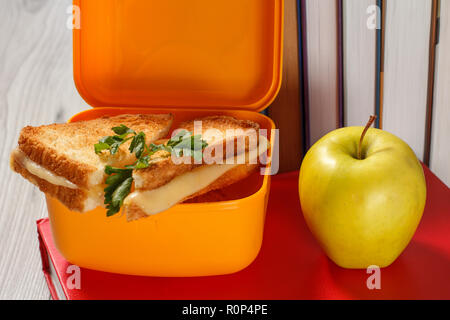Yellow lunch box with toasted slices of bread, cheese, a bottle of ...