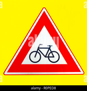 Yellow triangle road sign with a bicycle symbol indicating to motorist ...