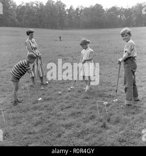 Young children playing croquet game outdoors in the garden, UK Stock ...