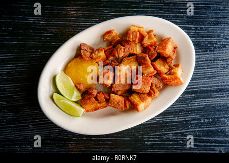 Colombian fried pork belly, chicharrón colombiano, with sliced limes ...