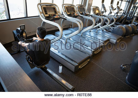 Man using rowing machine at gym Stock Photo - Alamy