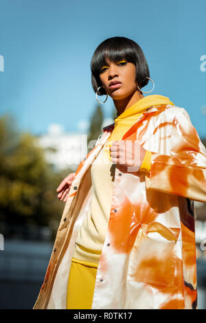 Trendy short haired african american model with golden earrings posing ...