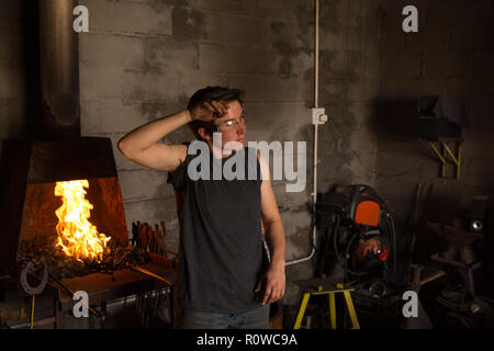 Female metalsmith standing in factory Stock Photo - Alamy