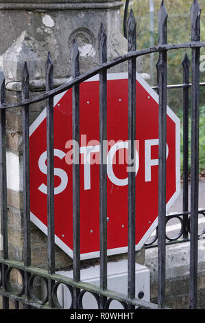 Stop sign with metal gate railing Stock Photo - Alamy