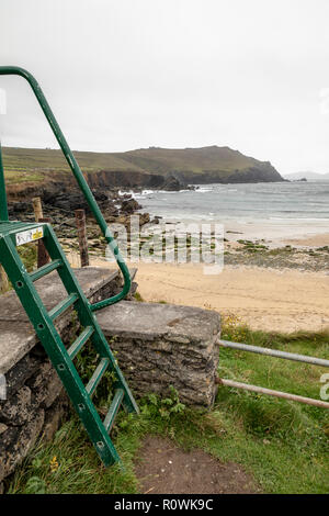 View from Clogher Strand beach, ocean, mountains and cloudy skies with ...