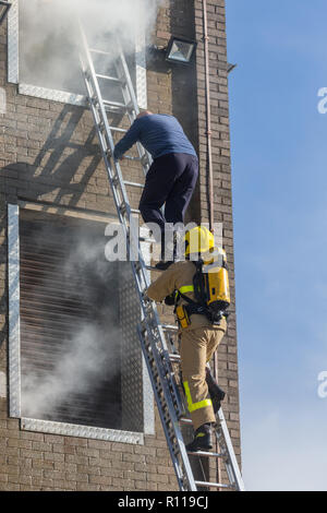 Firefighter rescuing during practice drill against clear sky Stock ...